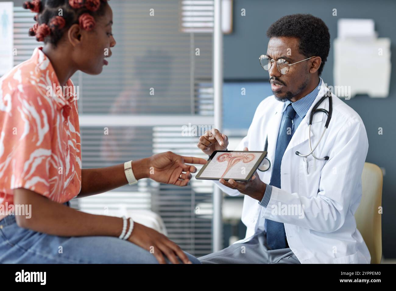Portrait of serious African American doctor as male obgyn holding ...