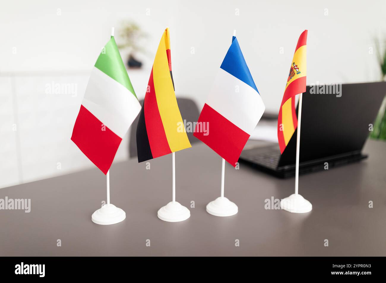 Multinational flags displayed on a desk in a modern corporate office ...