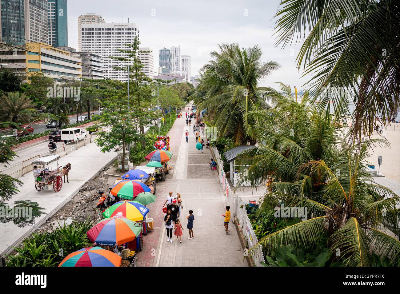 Pedestrians make their way along Manila Bay Walk in the Ermita District ...