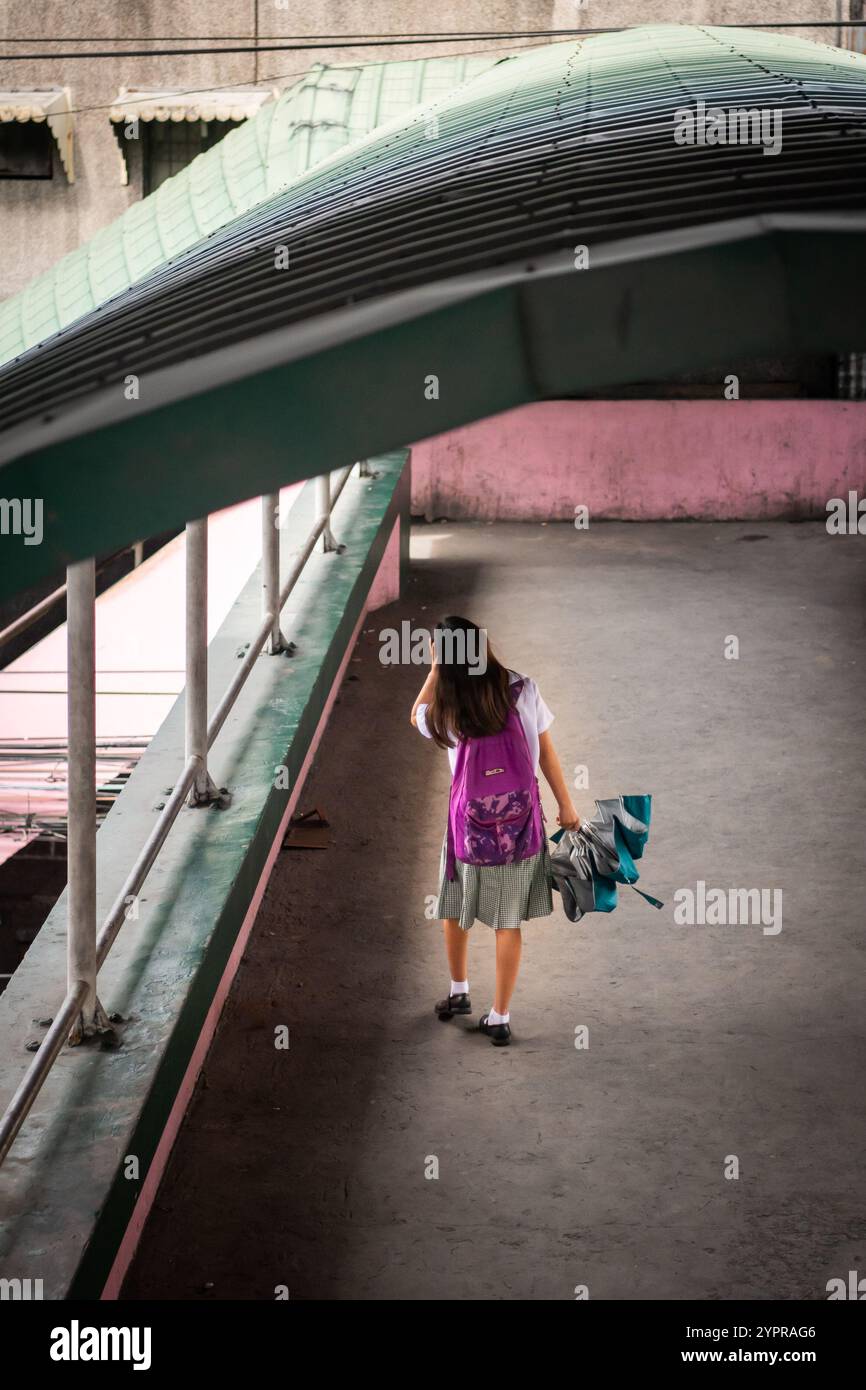 Pedestrians make their way along a footbridge over a busy road in ...