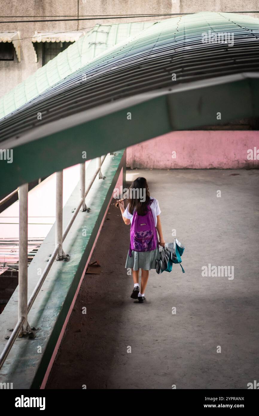 Pedestrians make their way along a footbridge over a busy road in ...