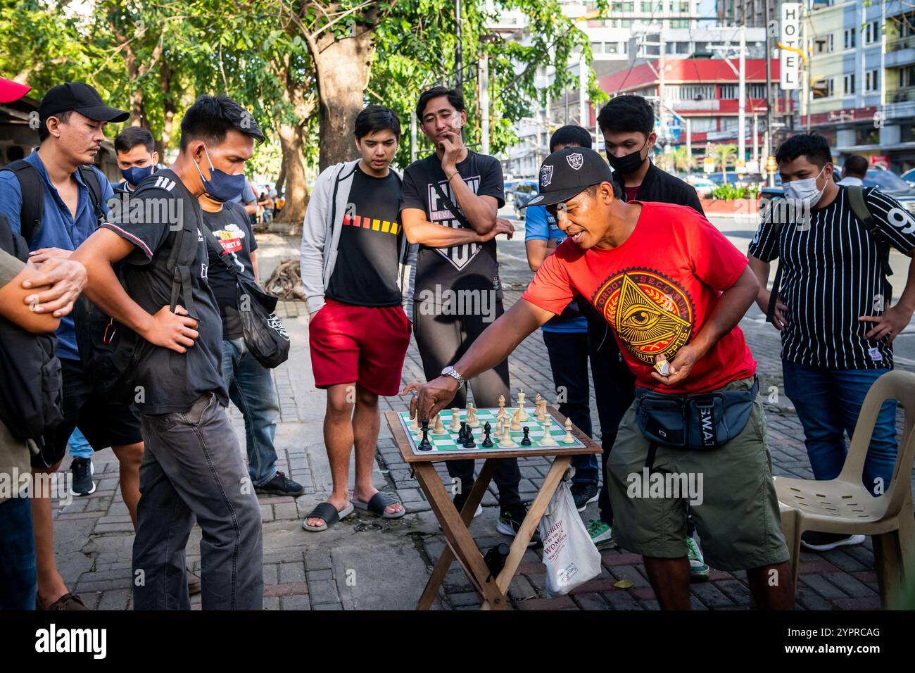 Filipino men enjoy a game of chess on the streets of Manila outside ...