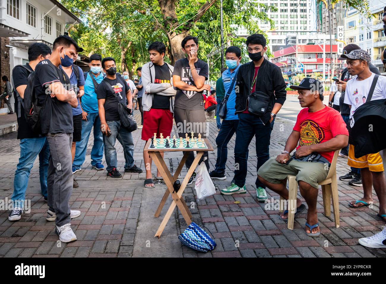 Filipino men enjoy a game of chess on the streets of Manila outside ...