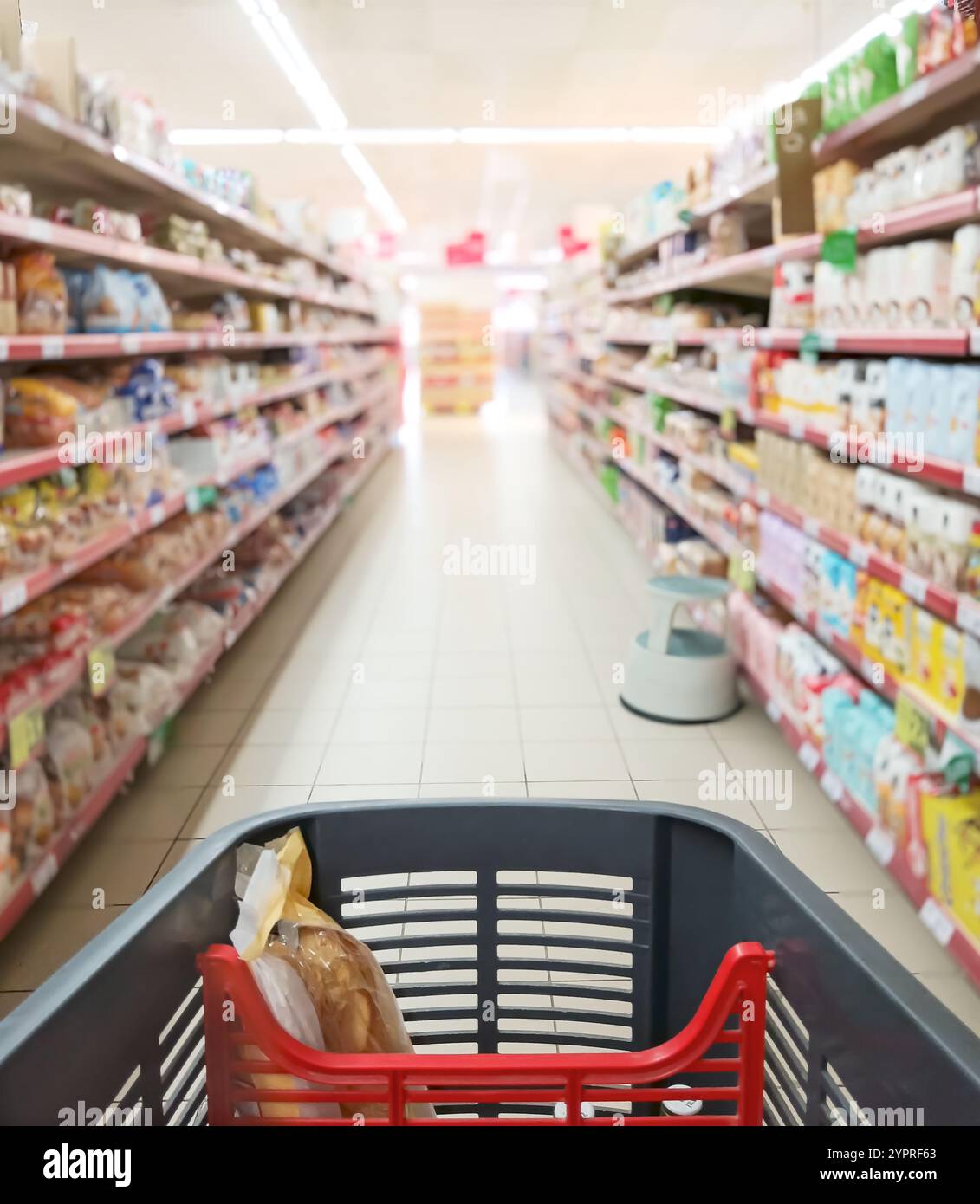 Shopping cart in a supermarket aisle Stock Photo - Alamy