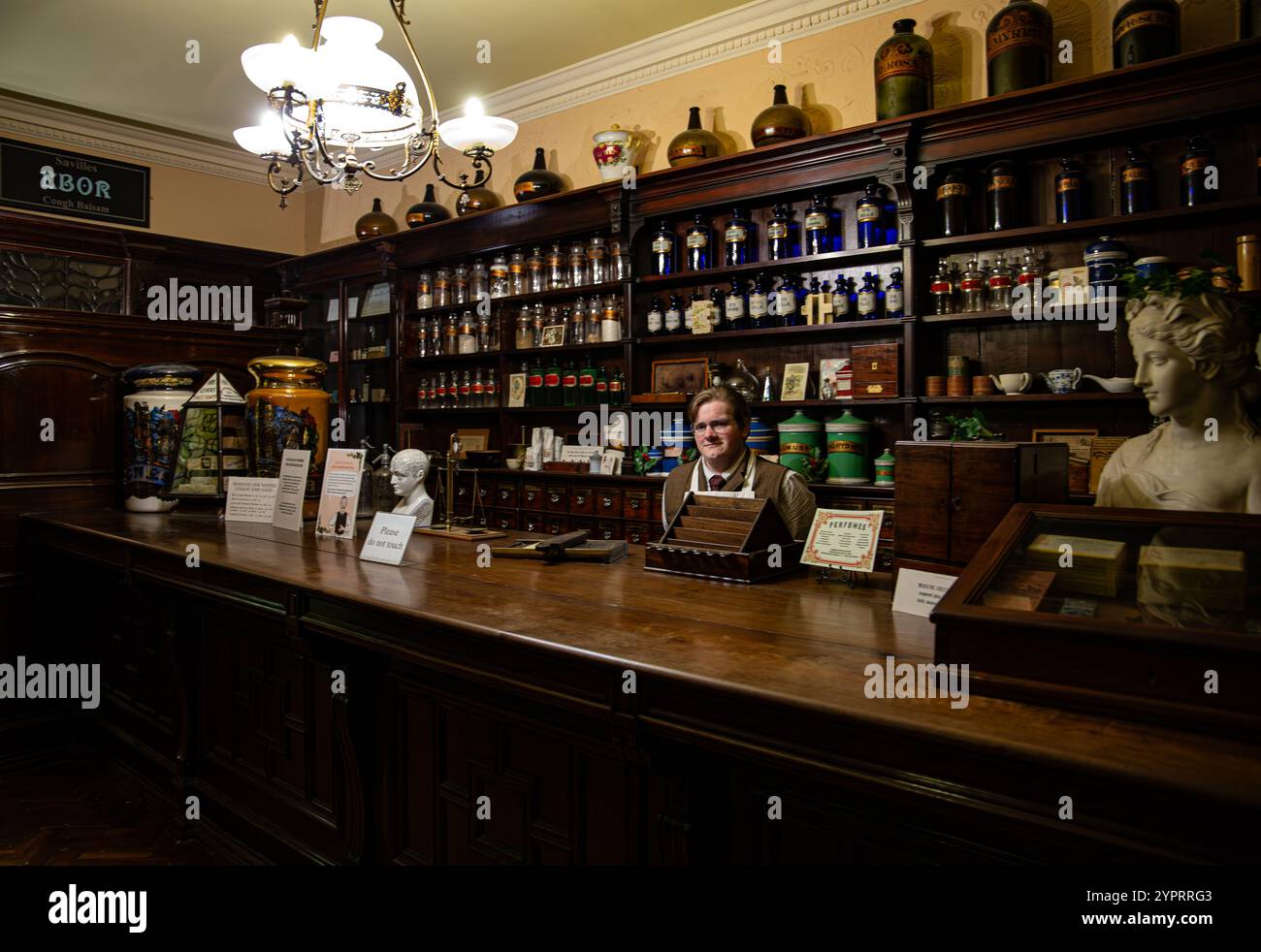 Vintage apothecary shop interior with dark wood shelves filled with ...