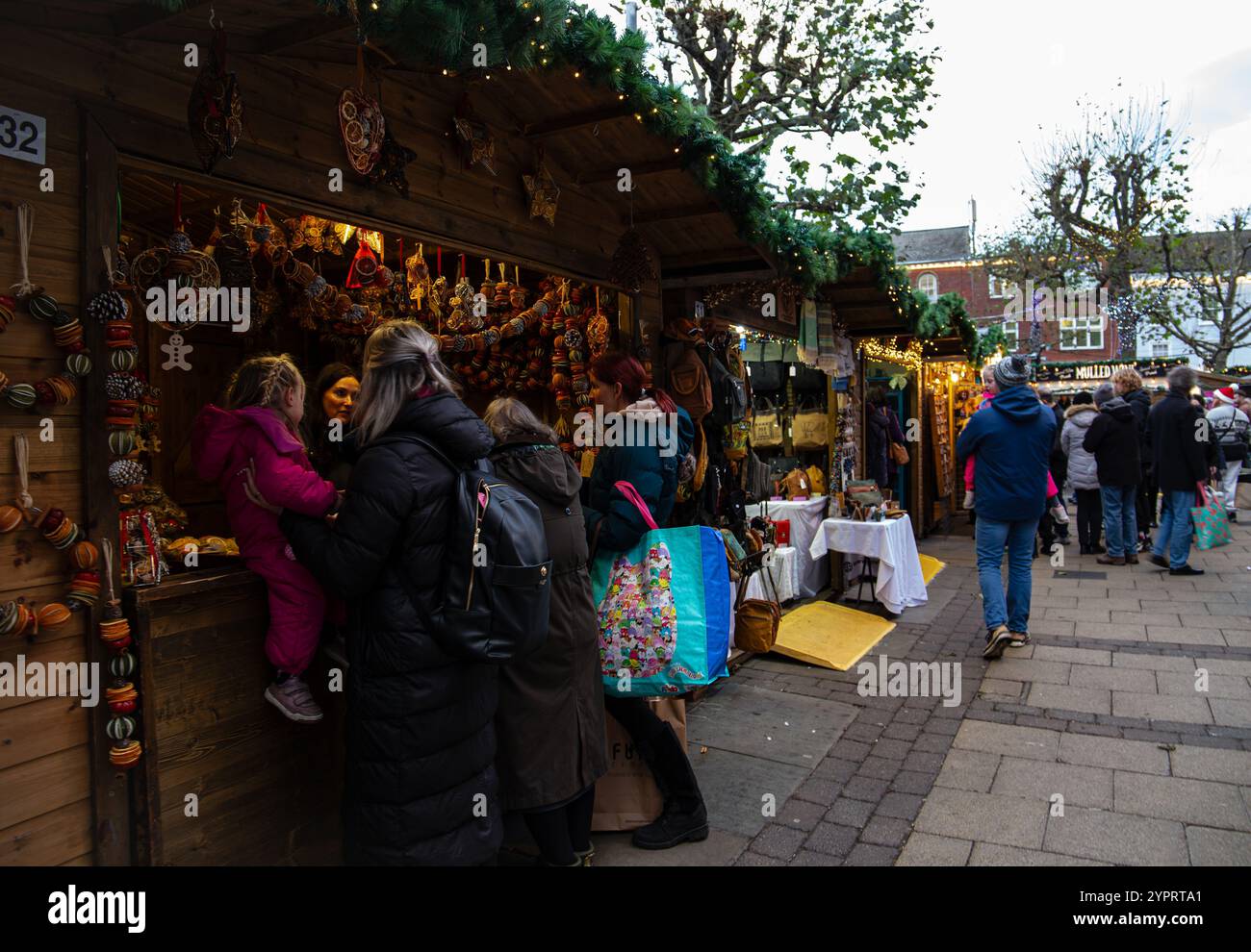 A bustling outdoor Christmas market with people shopping for ...