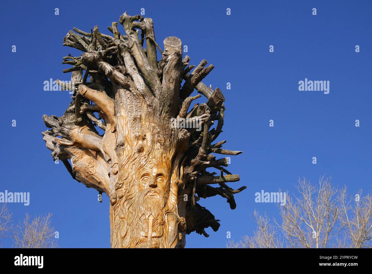 Carved wooden tree trunk pillar at the confluence of the main branch of ...