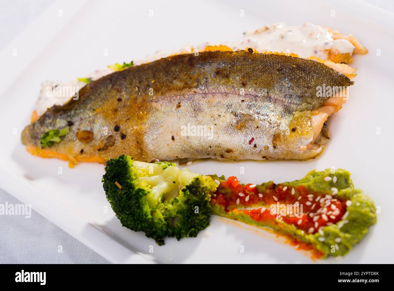 Baked rainbow trout with broccoli, tartare sauce on white dish Stock ...