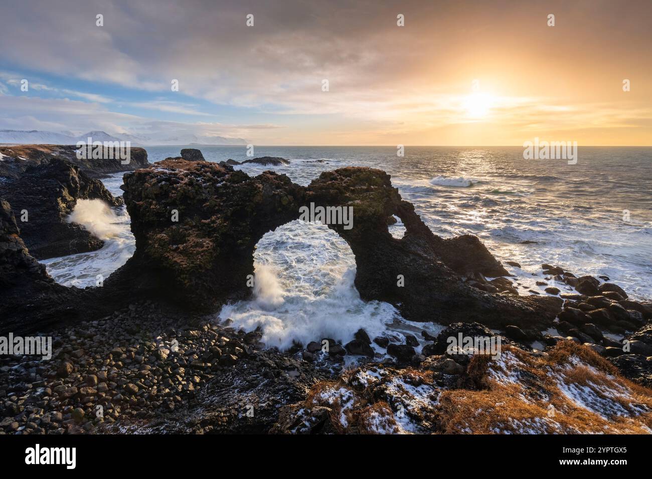 View of the Gatklettur rock arch at sunrise in winter. Arnarstapi ...