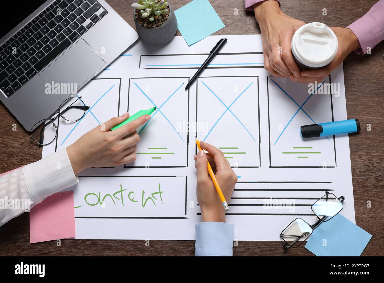 Developing UI design. Designers creating website wireframe on paper at ...