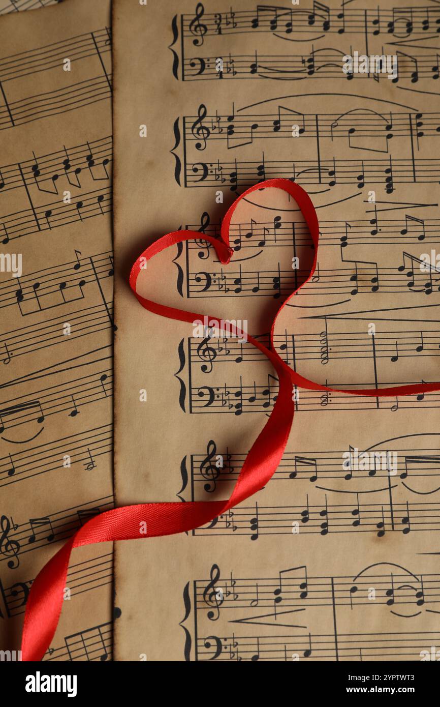 Heart shaped ribbon on musical notes, top view Stock Photo - Alamy