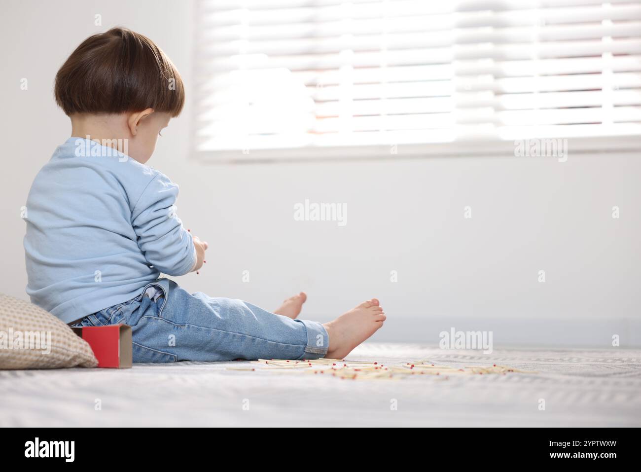 Little boy playing with matches at home, space for text. Child in ...
