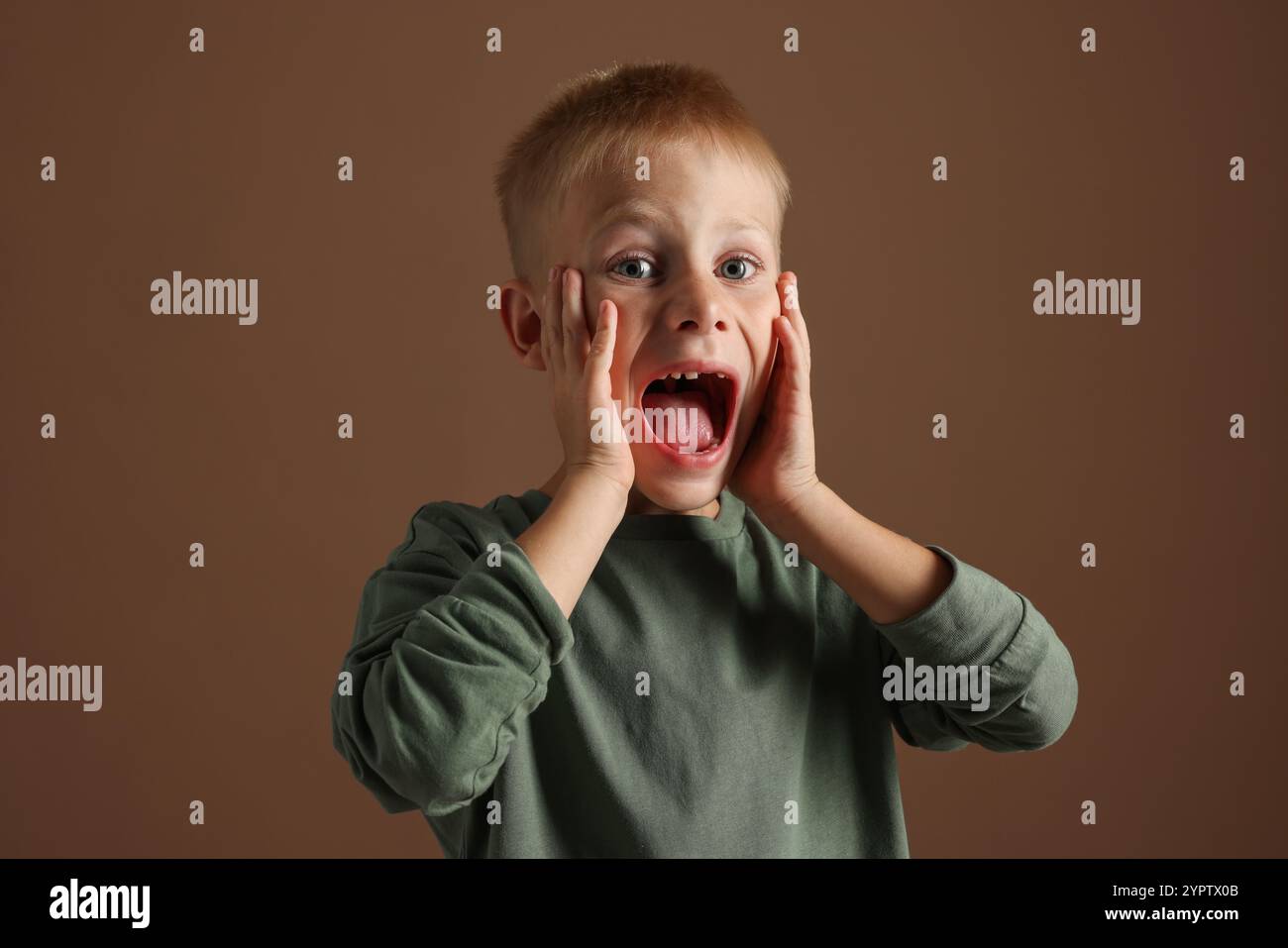 Scared little boy screaming on brown background Stock Photo - Alamy