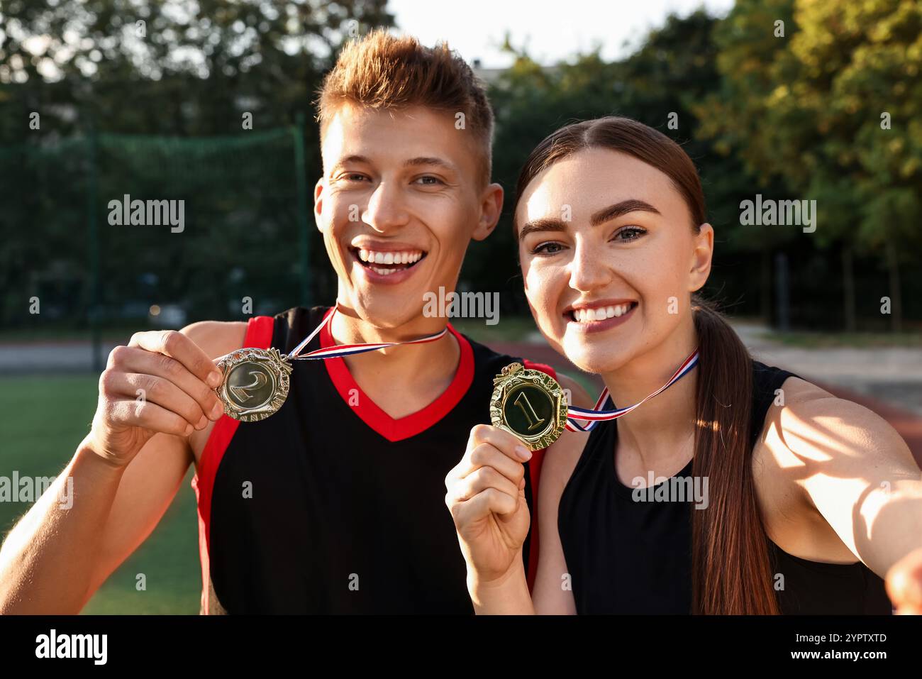 Happy winners with medals taking selfie at stadium Stock Photo - Alamy