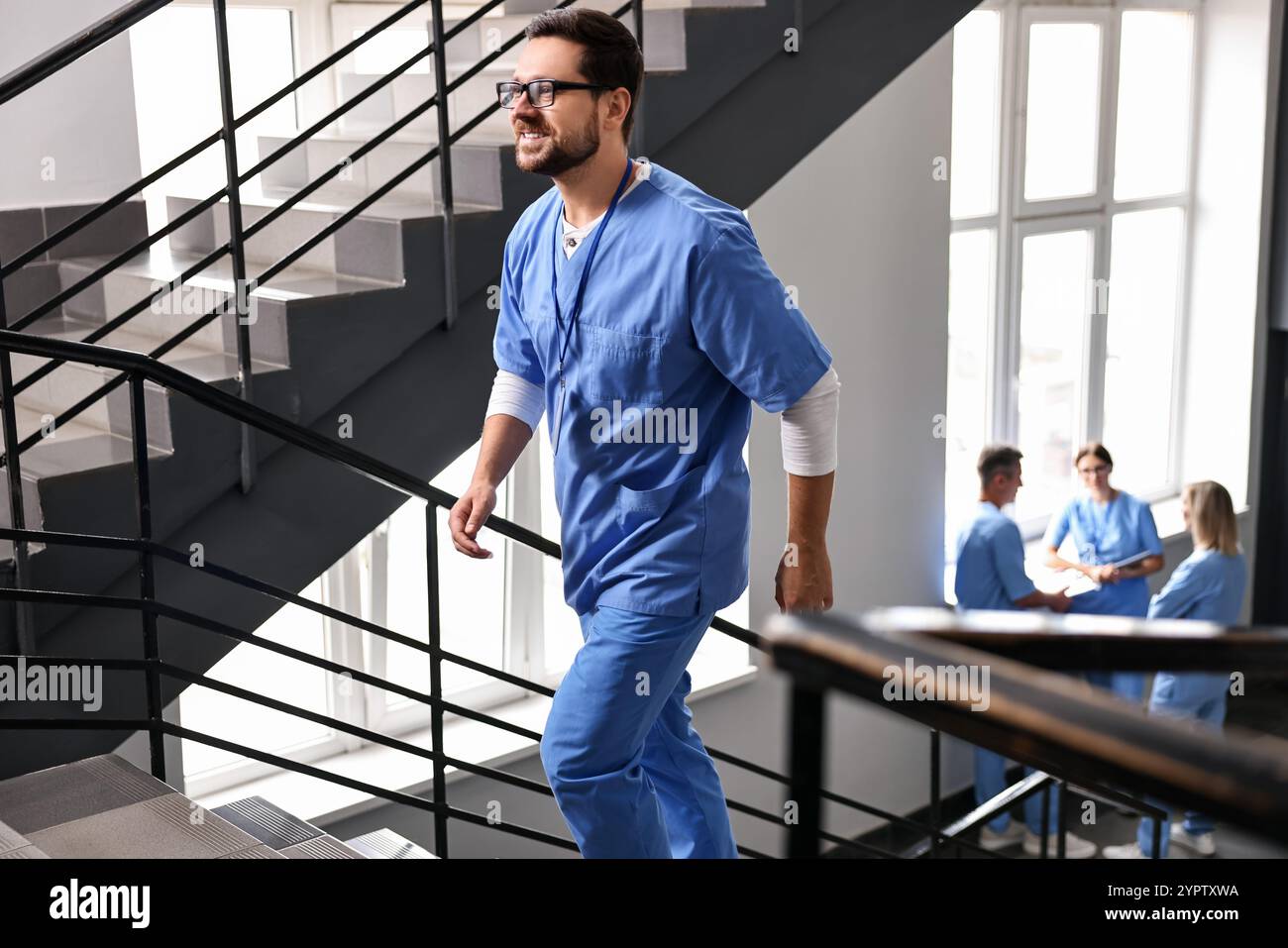 Healthcare worker walking up stairs in hospital Stock Photo - Alamy