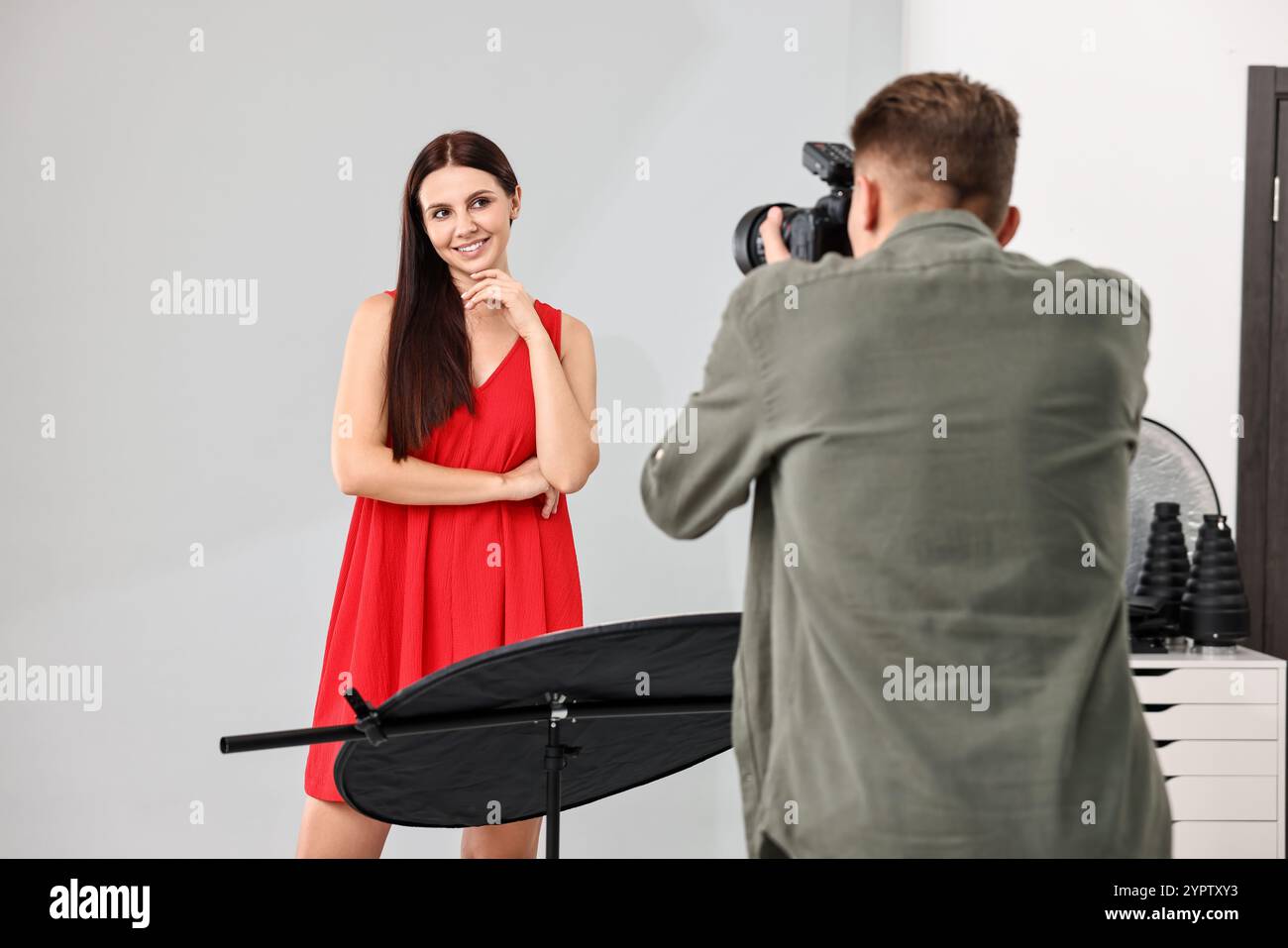 Photographer working with model in professional photo studio Stock ...