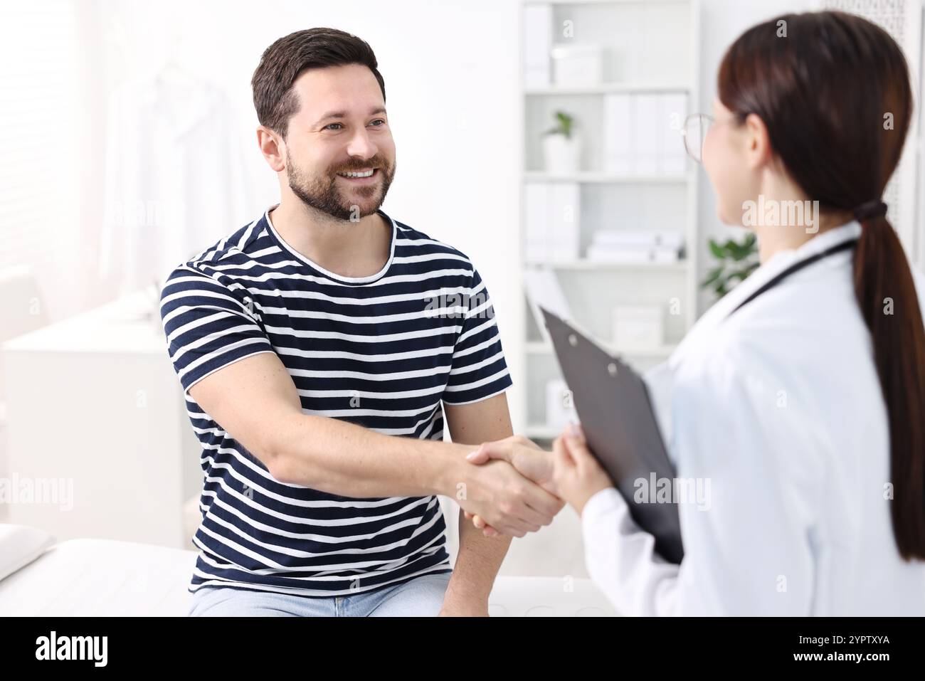 Healthcare worker shaking hands with patient in hospital Stock Photo ...
