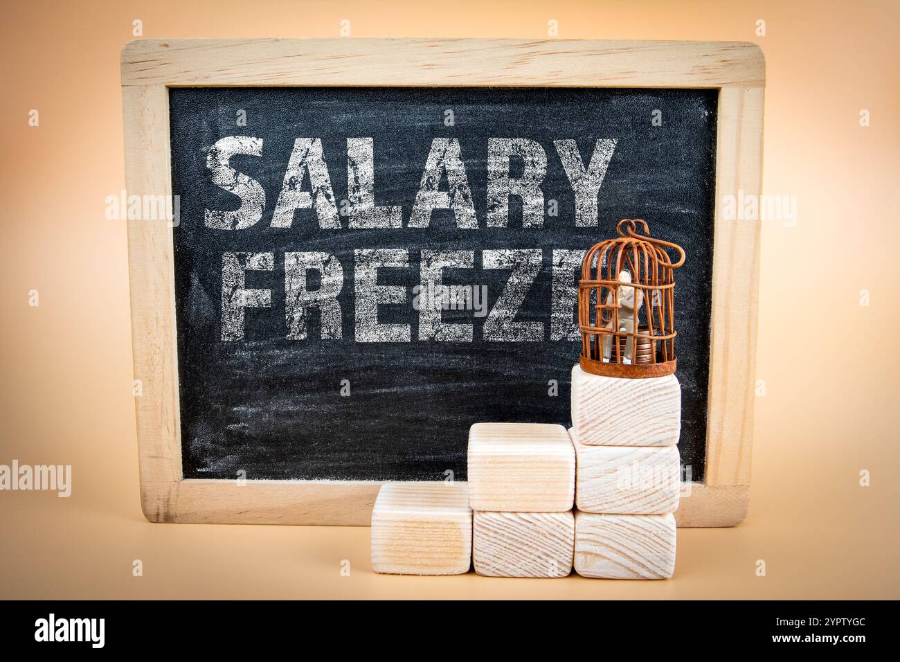 Salary Freeze Concept. Miniature chalk board with text on a light ...