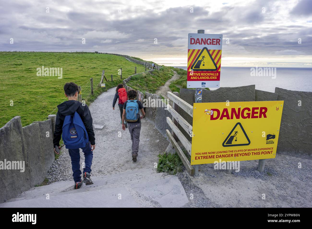Hikers and danger sign, Cliffs of Moher, The Burren, County Clare ...