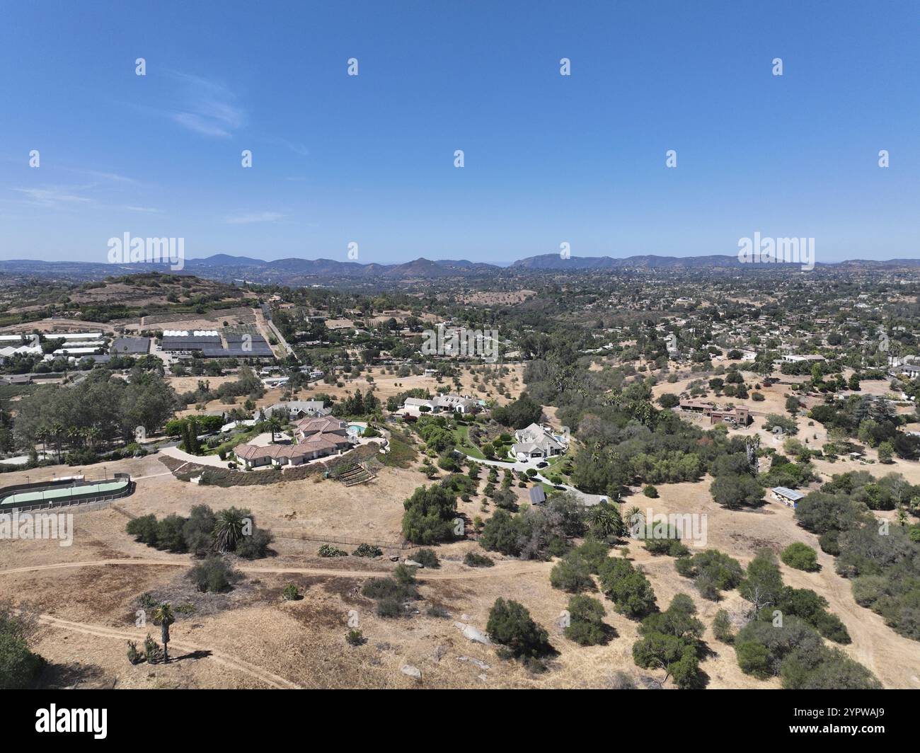Aerial view of dry valley and land with houses and barn in Escondido ...