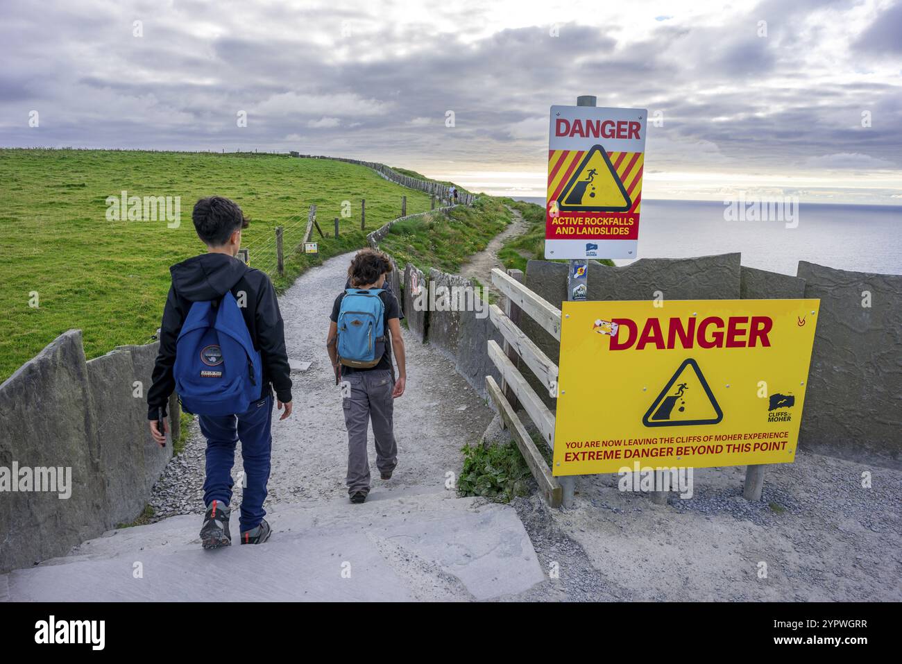 Hikers and danger sign, Cliffs of Moher, The Burren, County Clare ...