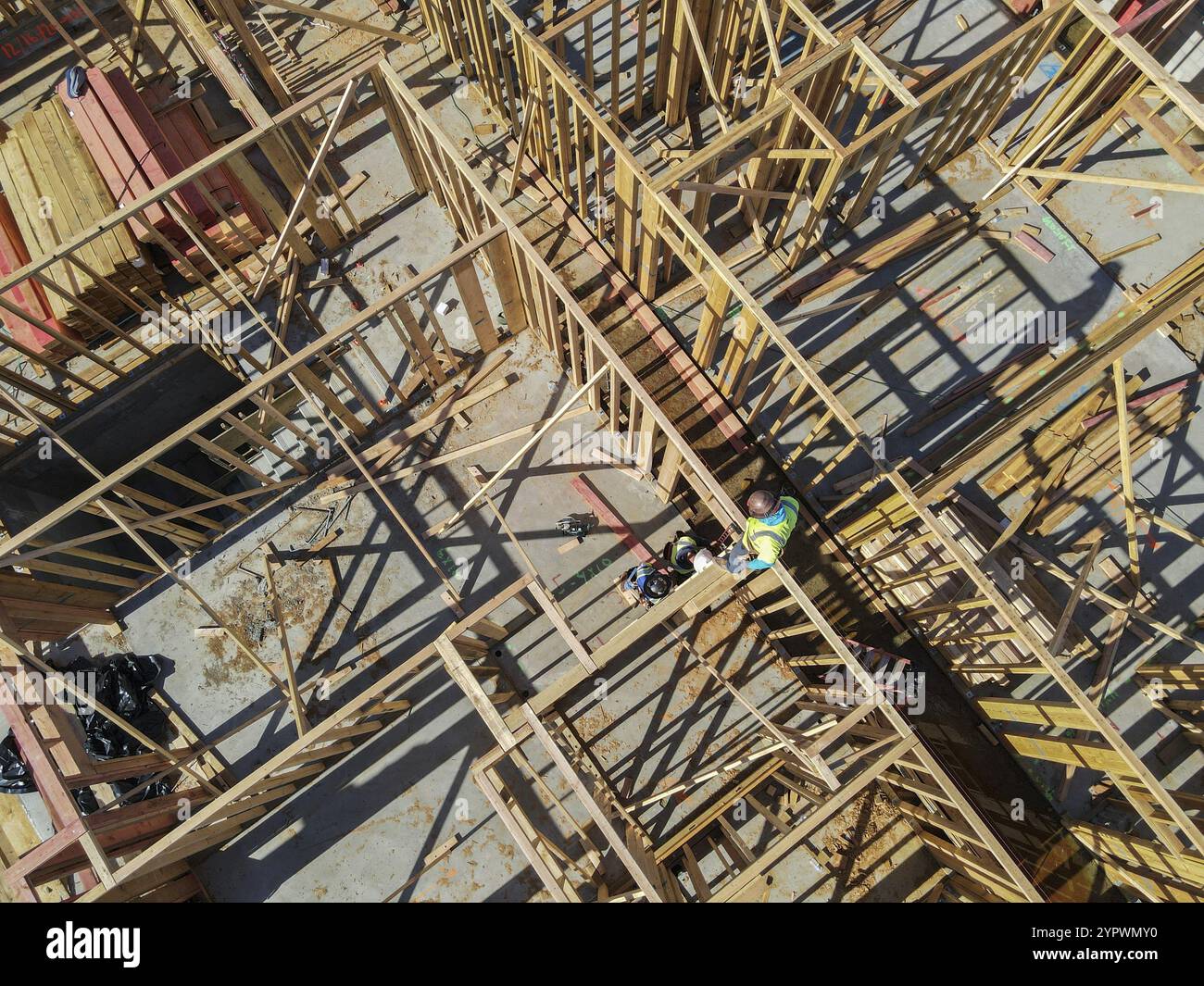 Aerial view of a new building being framed by carpenters. Worker ...