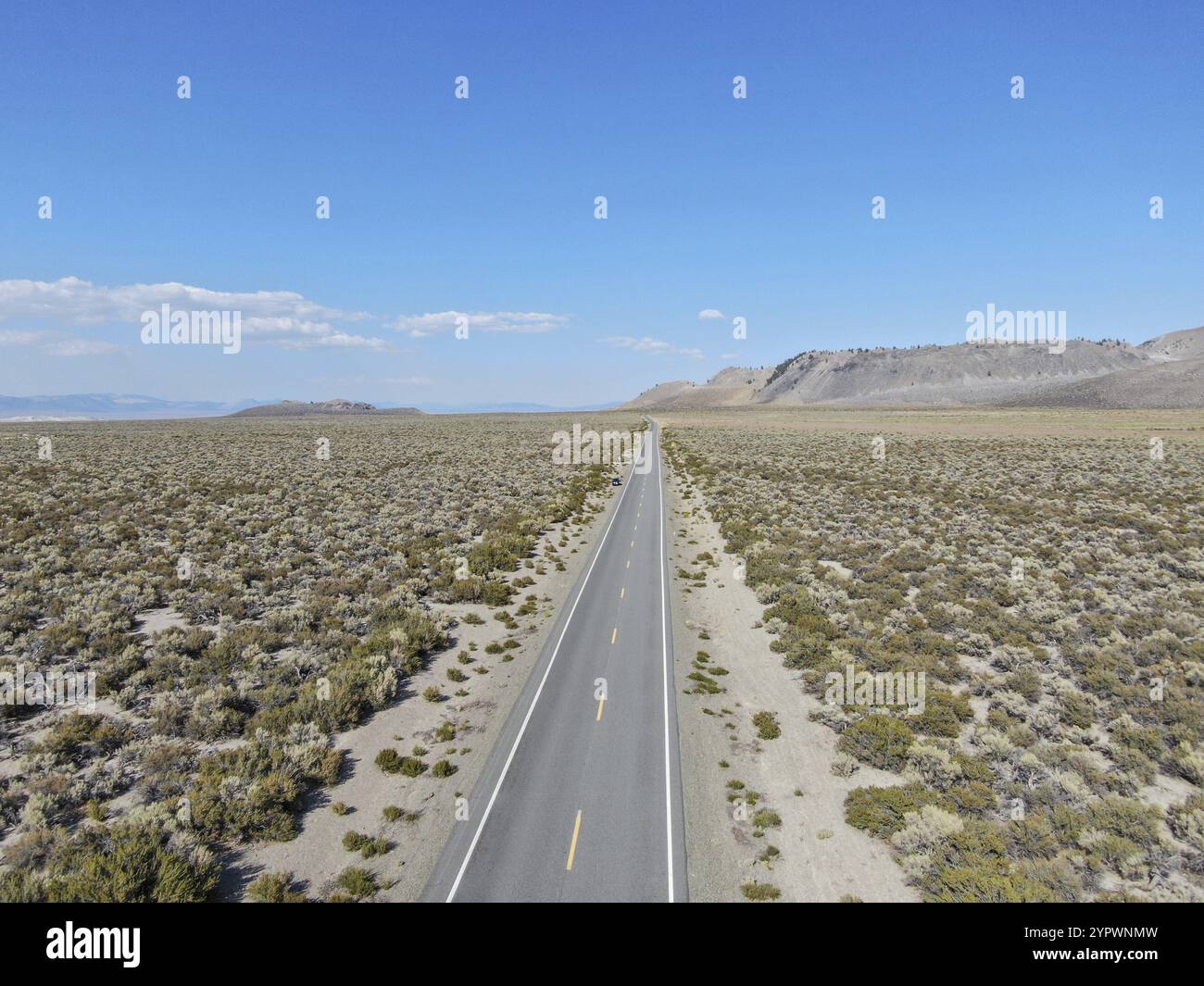 Aerial view of asphalt road in the middle of dusty dry desert land in ...