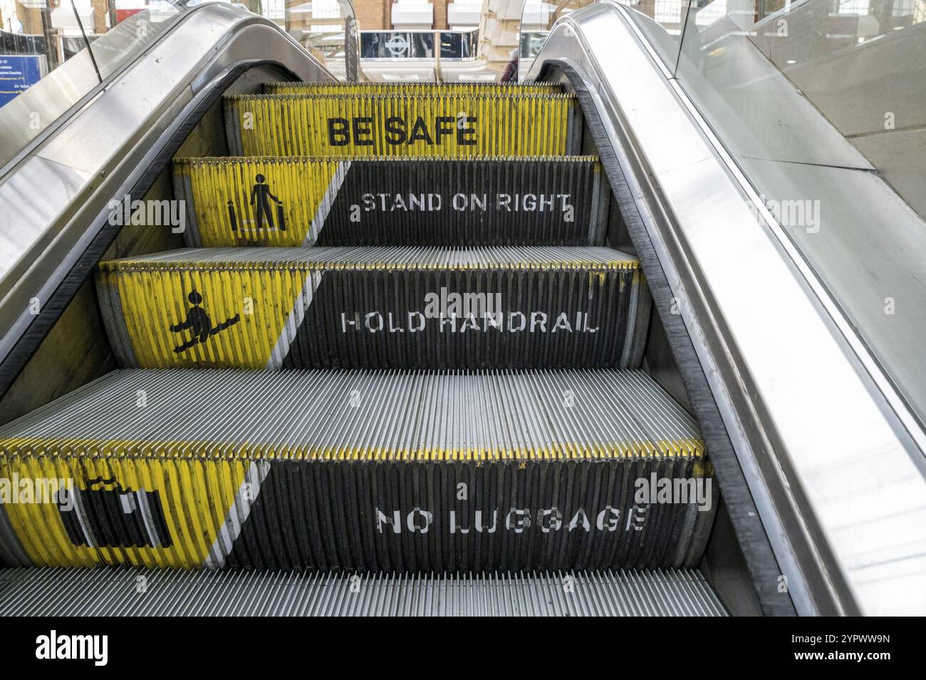 Escalator at the train station with step riser messaging, please be ...
