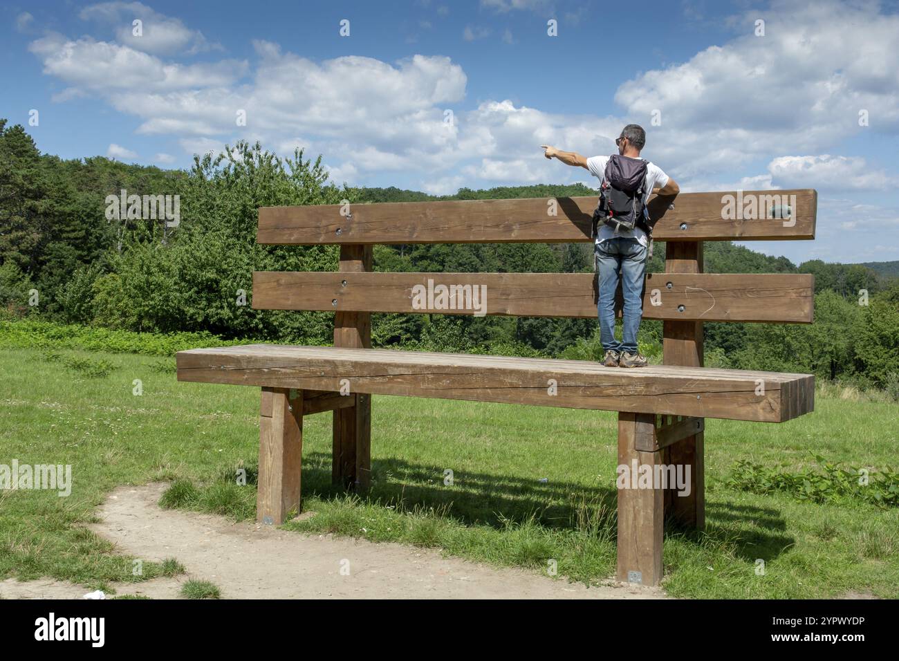 Unique brown giant wooden bench with unrecognizable man pointing to the ...