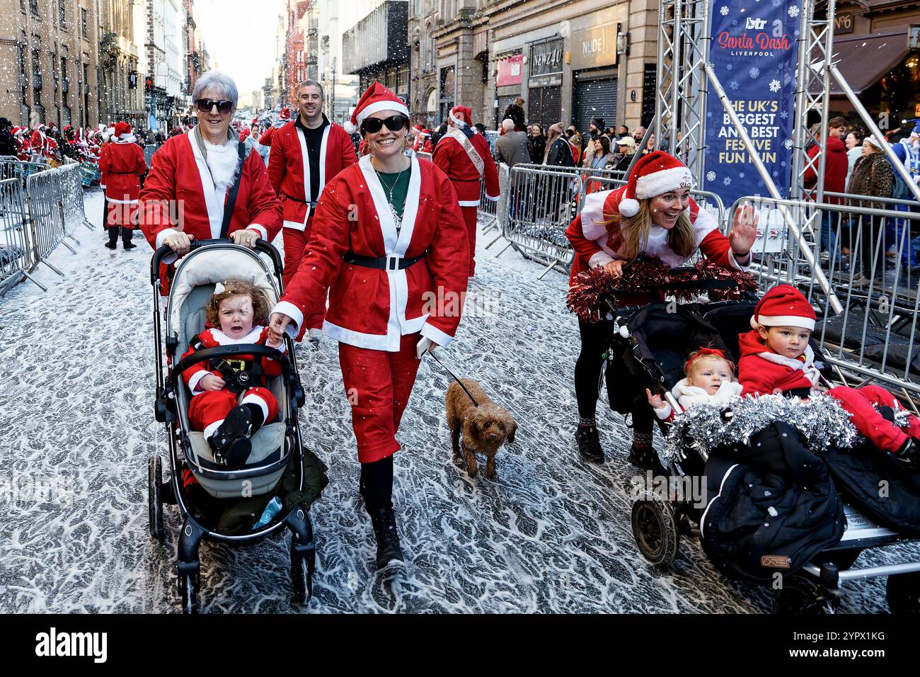 Family arrives at the finishing line of the Liverpool Santa Dash 2024 ...
