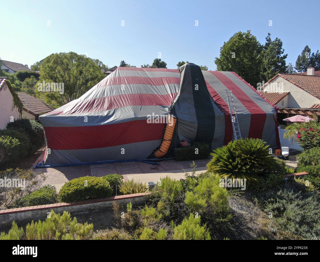 Aerial view of villa covered with a red and green tent while being ...
