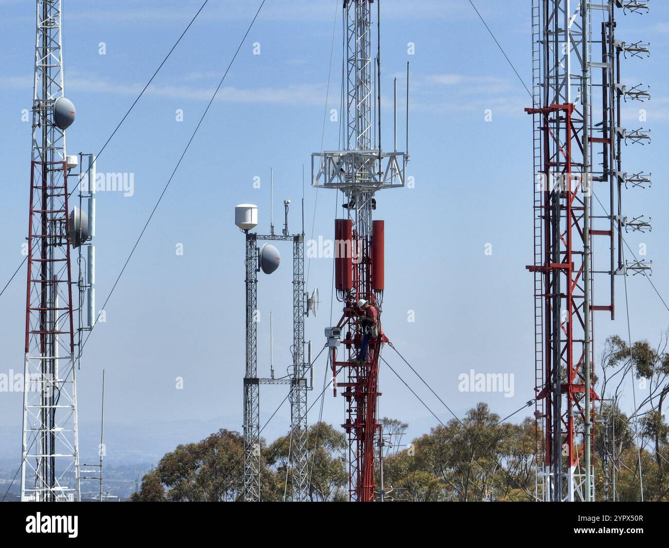 Engineer with safety equipment on high tower for working telecom ...