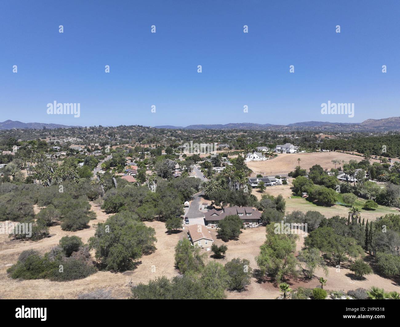 Aerial view of dry valley and land with houses and barn in Escondido ...