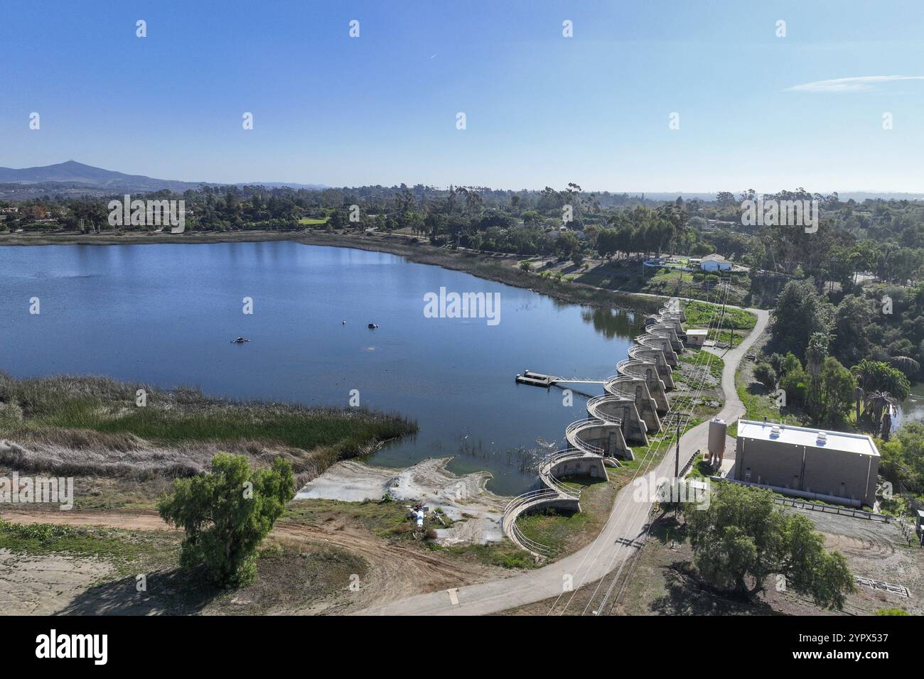 Aerial view over water reservoir and a large dam that holds water ...