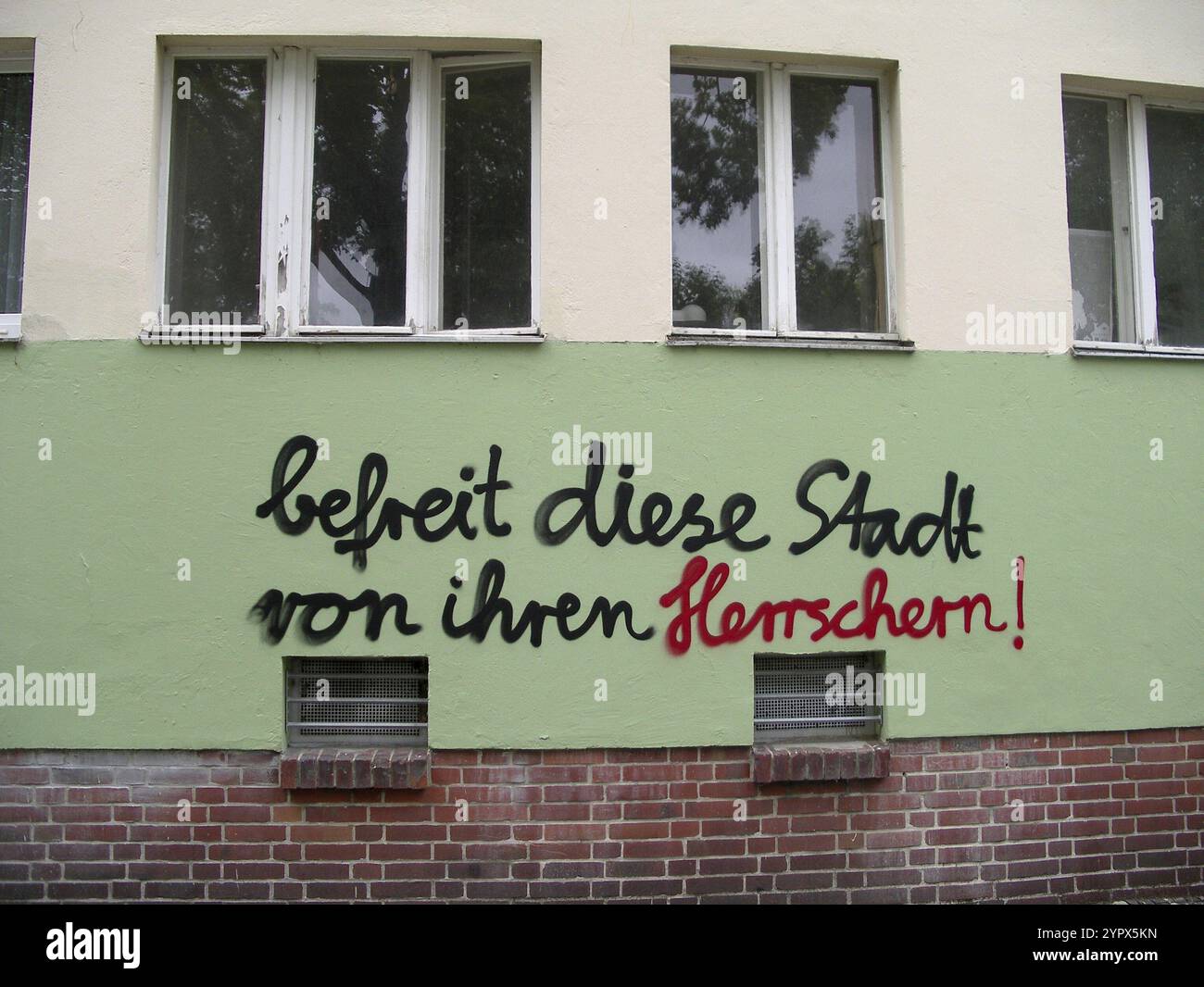 Subersive-revolutionary slogan as graffito on a Kreuzberg house wall ...