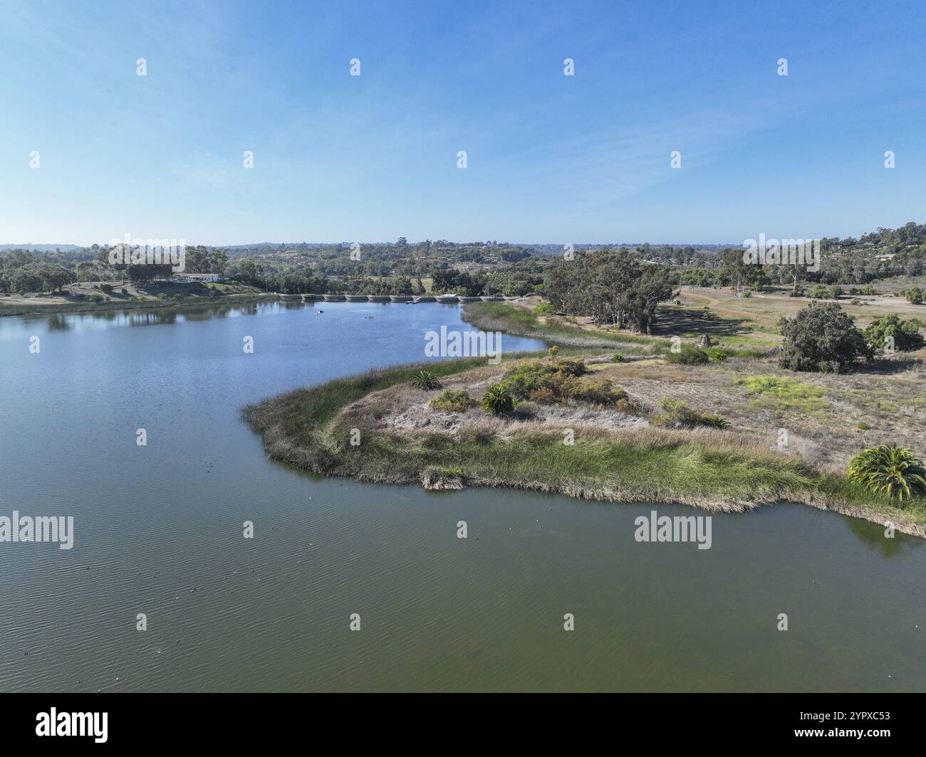 Aerial view over water reservoir and a large dam that holds water ...