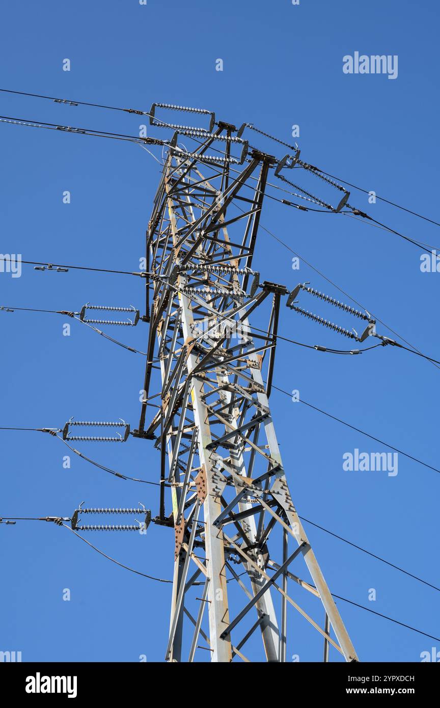 High voltage power lines and green power pylon against blue sky ...