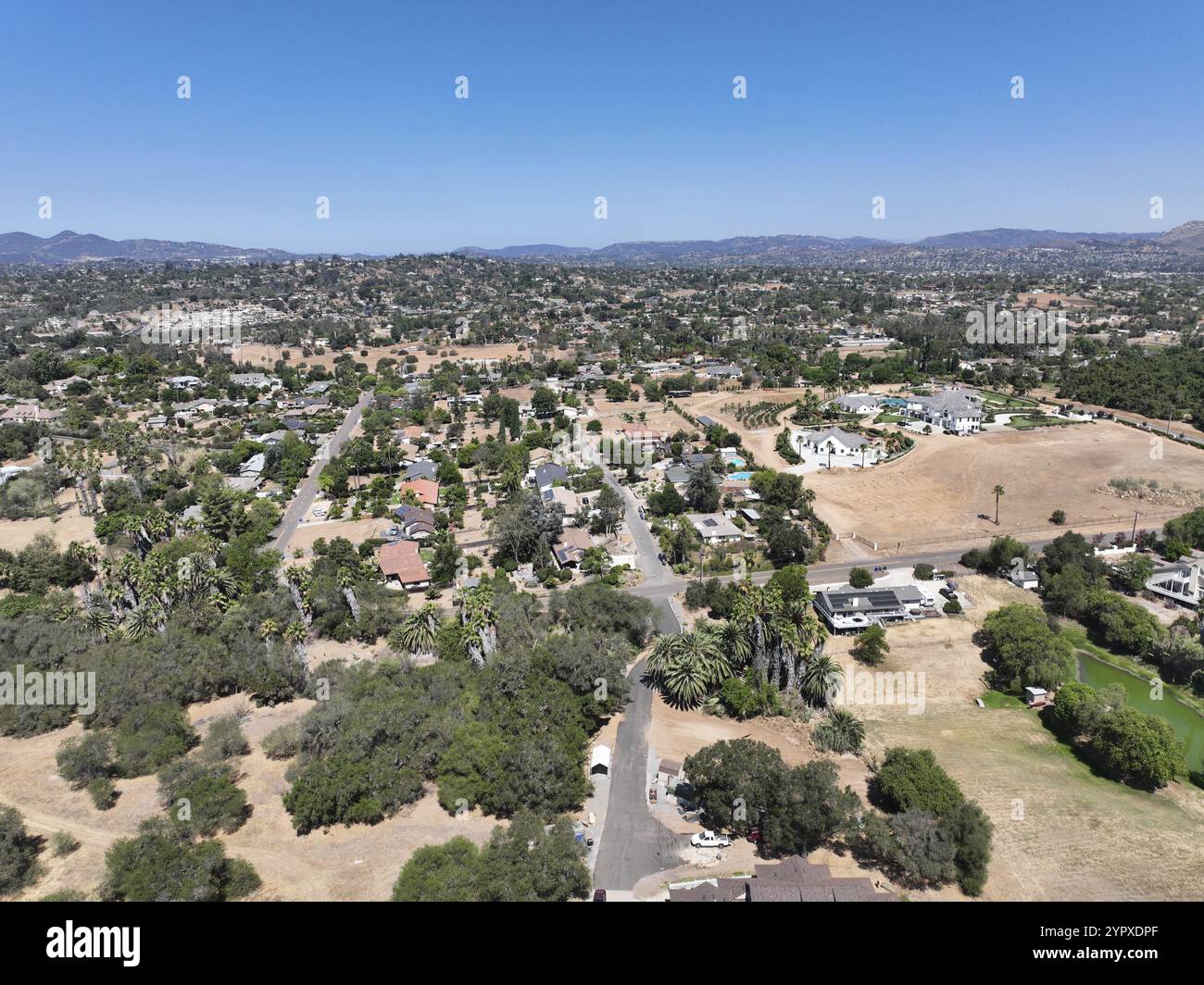 Aerial view of dry valley and land with houses and barn in Escondido ...