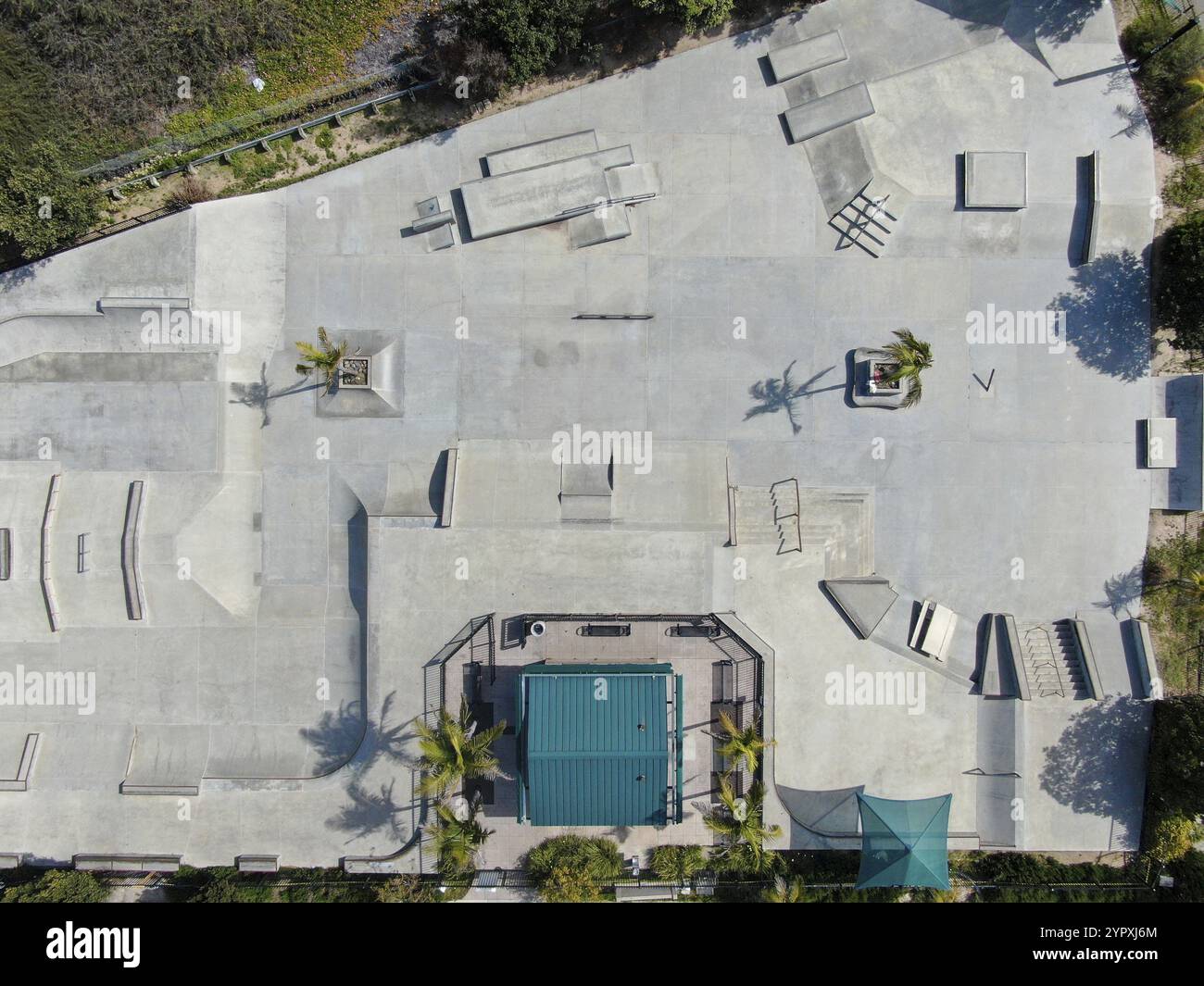 Aerial view of outdoor empty concrete skate park with ramps and pipes ...