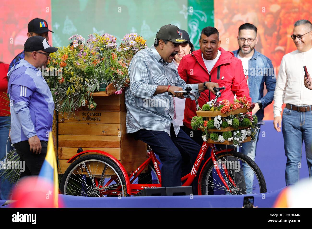 Venezuelan President Nicolas Maduro rides a bicycle during a march in ...