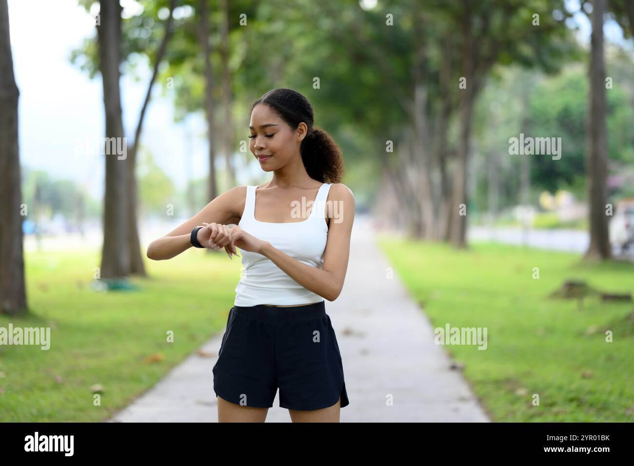 Active young woman monitoring fitness progress on her smartwatch Stock ...