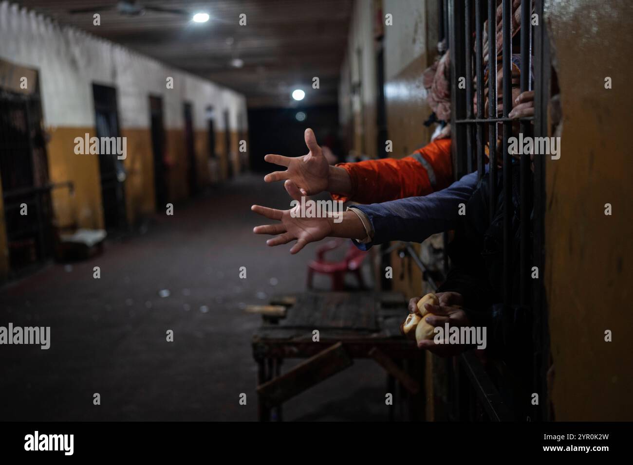 Prisoners reach out from their cell for bread at lunchtime at the Juan ...