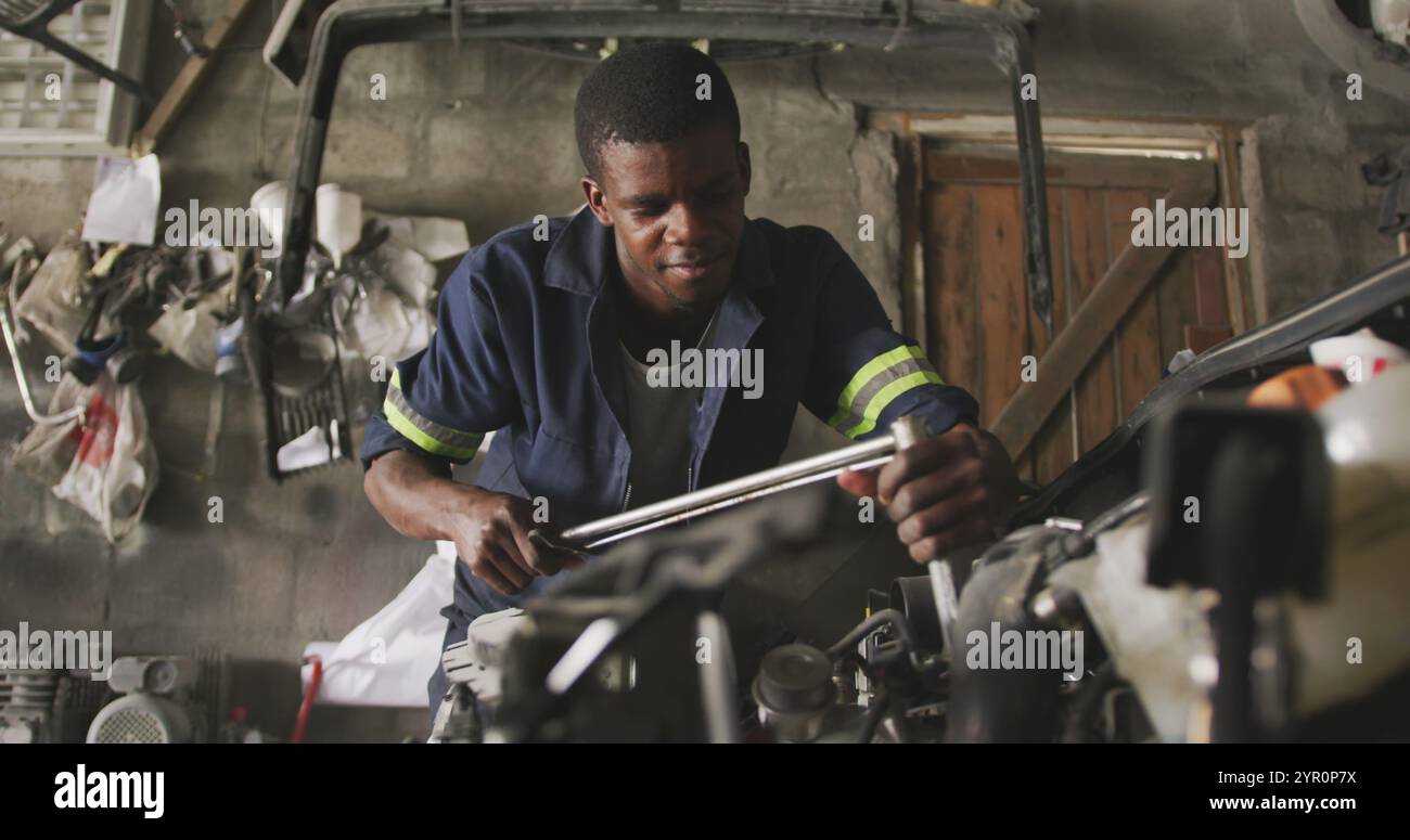 Front view of an African male car mechanic in a township workshop ...