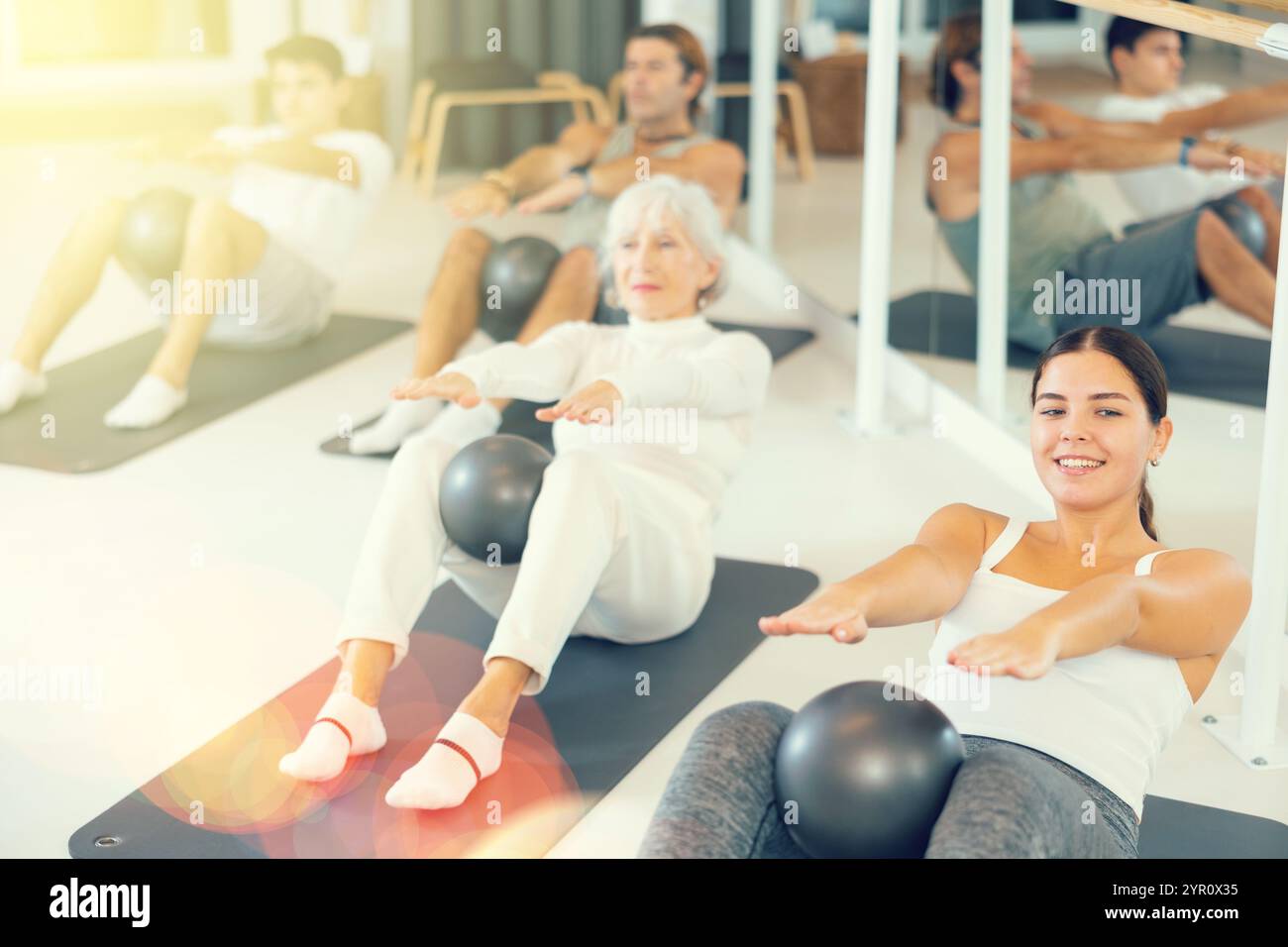 Group of different people doing exercises with ball Stock Photo - Alamy