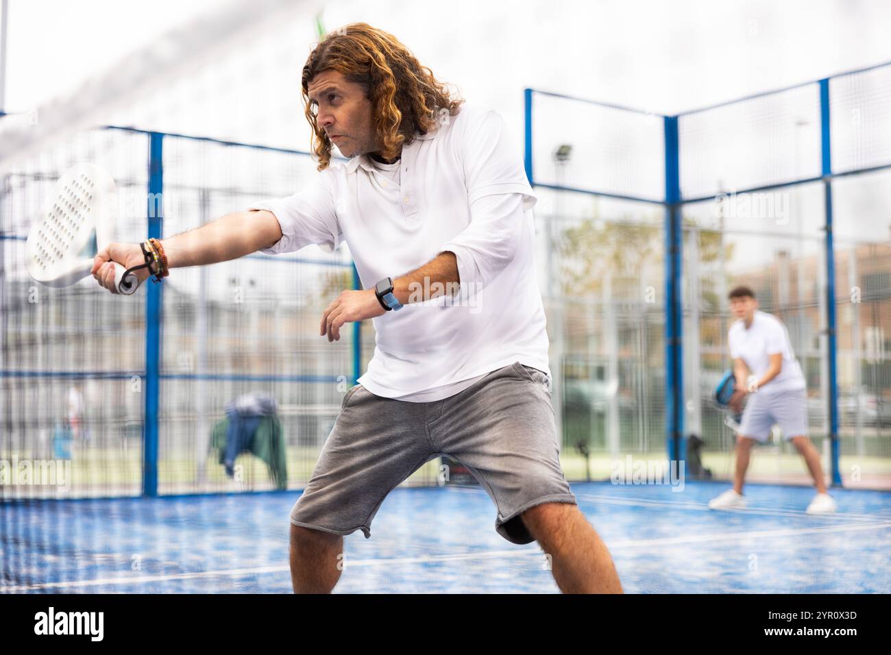 Male players playing padel in a padel court outdoor behind net Stock ...