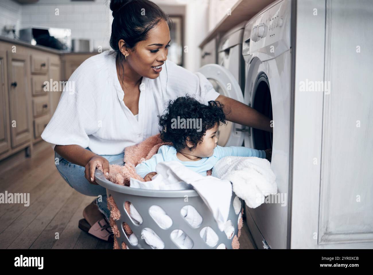 Mother, baby and washing machine for laundry in home, helping mom and ...