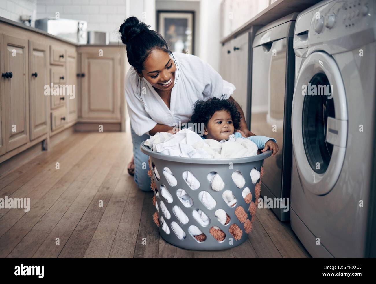 Mom, baby and playing with laundry basket in home, helping and ...