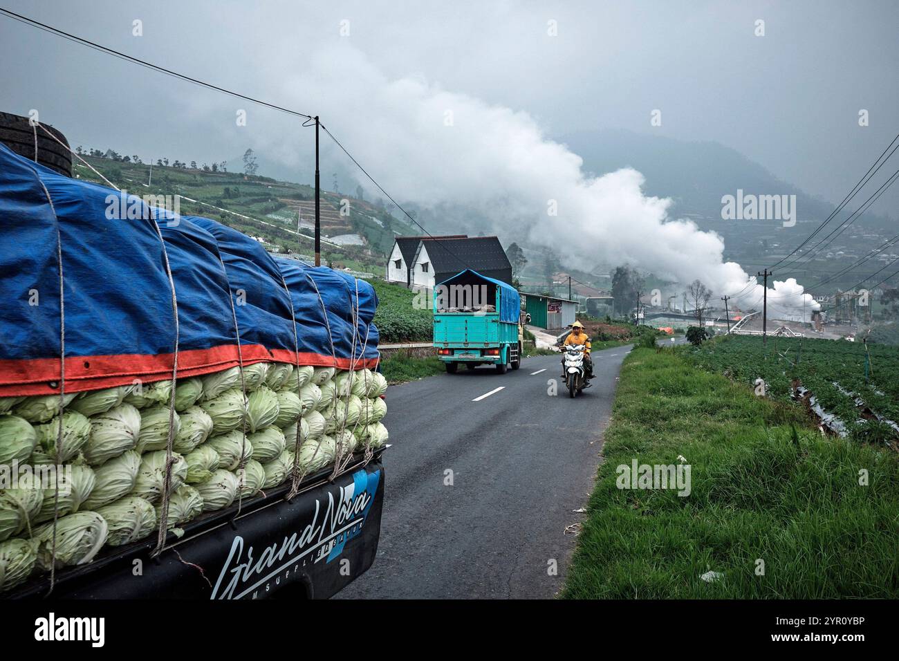 Steam rises from a geothermal power plant as a motorist rides past by ...