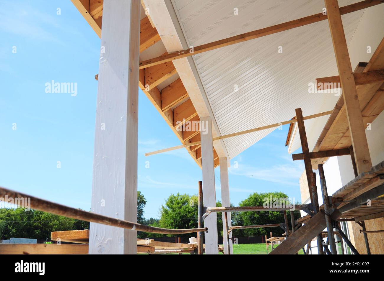 Building house patio roofing with wooden pillars and unfinished soffits ...
