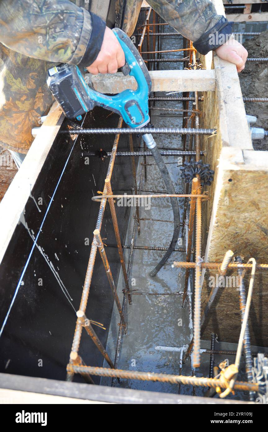 Contractor mix concrete in foundation slabs with iron bars. Mixing ...